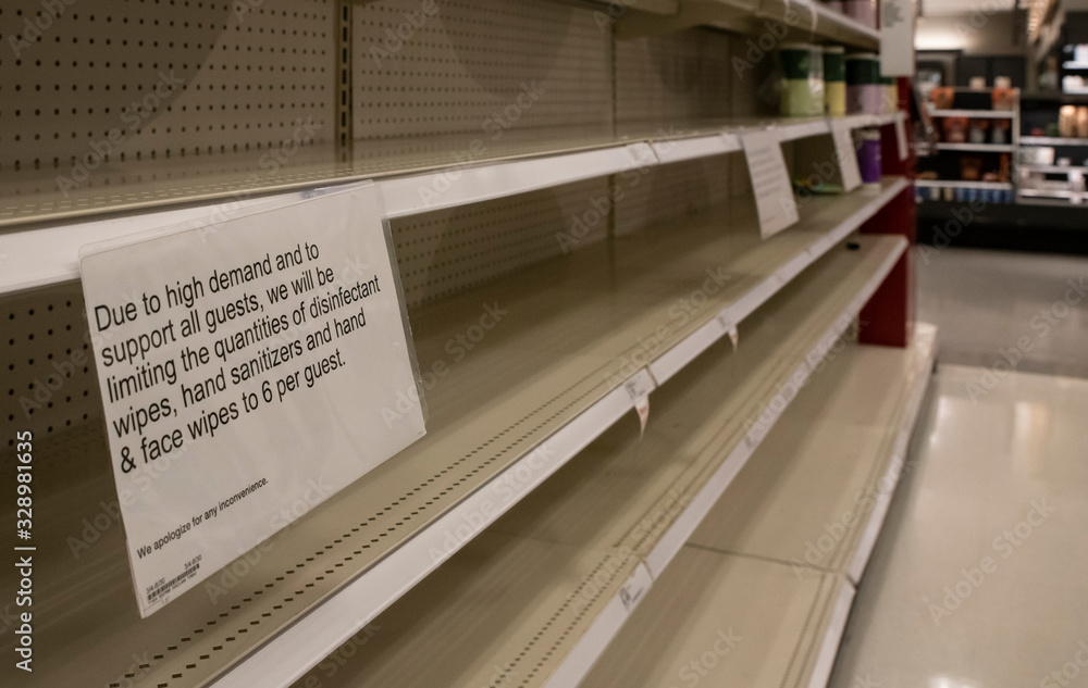 Empty shelves of cleaning supplies are accompanied by a sign limiting ...