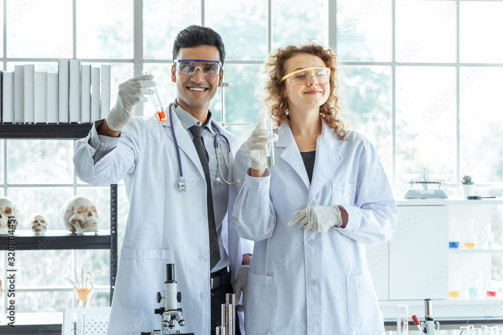 Young successful scientist performing an experiment in modern chemical ...