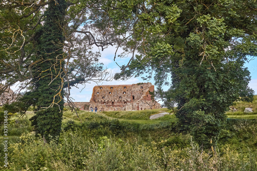 Tourists visiting ruins of The Storage House in Hammershus castle ...
