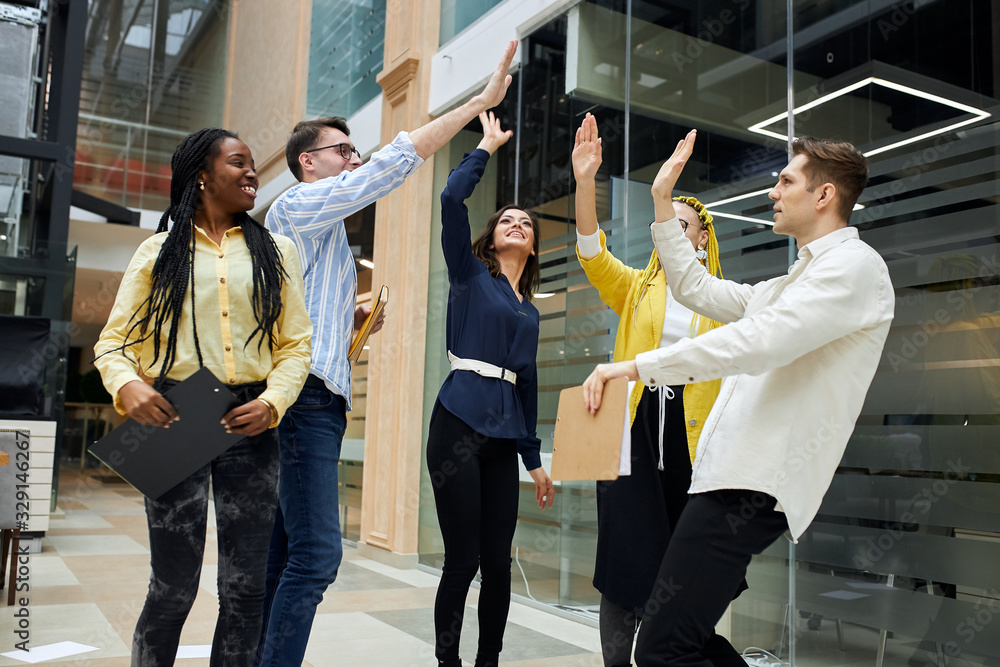 cheerful awesome team giving high five to each other, celebrating ...