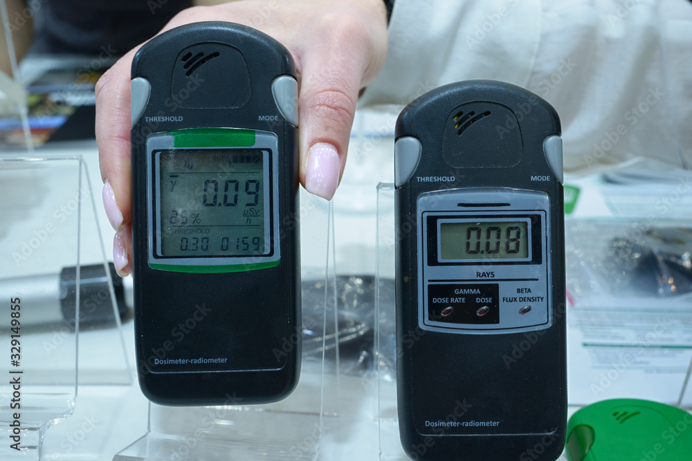 Customer hand holding personal dosimeter-radiometers for measuring ...