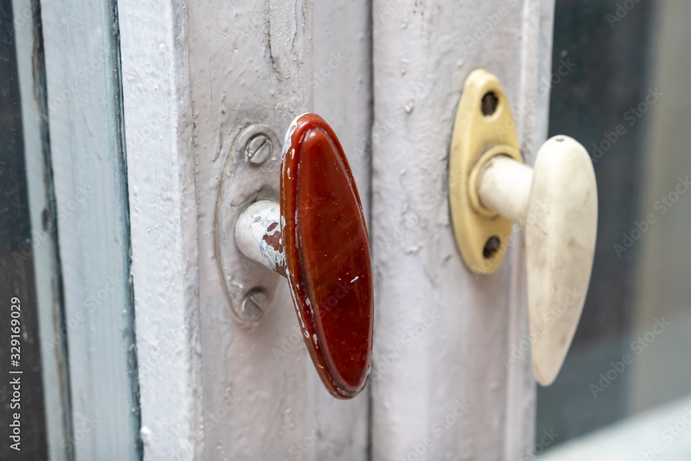 Handles on an old wooden window with peeling paint needed to be ...