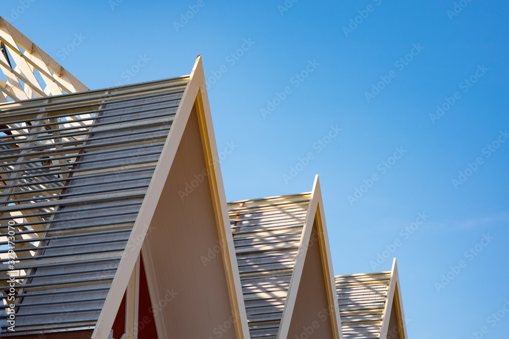 Low angle and side view of 3 wooden gable roofs structure under ...