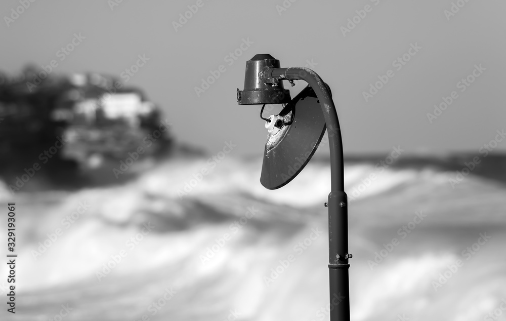 Black and white photo of a broken lamp post by the sea after storm ...