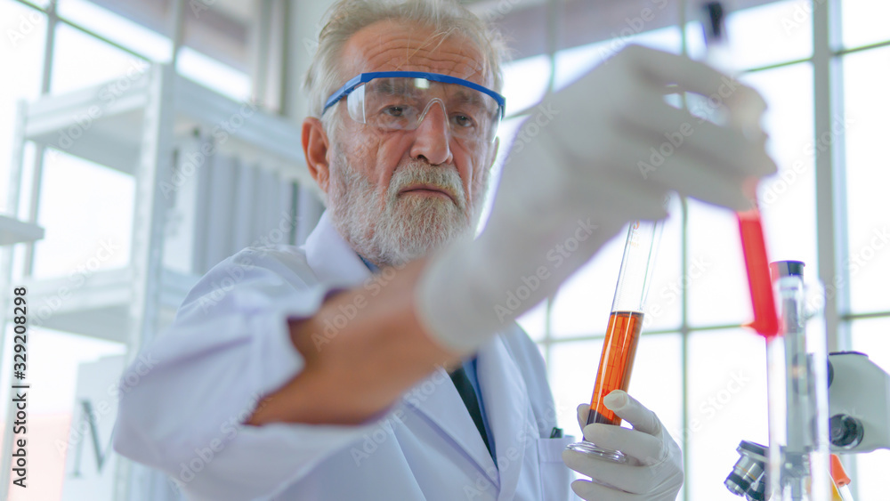 Senior professor male researcher tests a chemical liquid tube with face ...