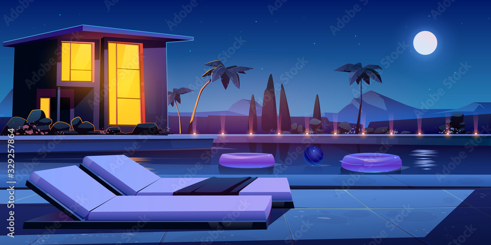 House and swimming pool with deck chairs and balls in water at night ...