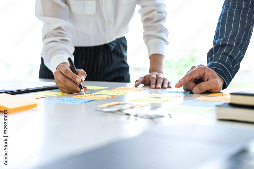 Two creative business people meeting and planning use post it notes ...