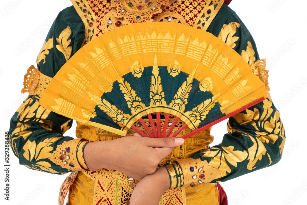 Cropped of hand hold a fan portrait of Balinese dancer wear traditional ...