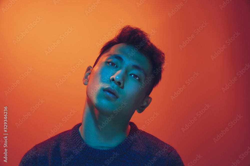 Portrait of a guy with colorful neon light on gradient studio ...