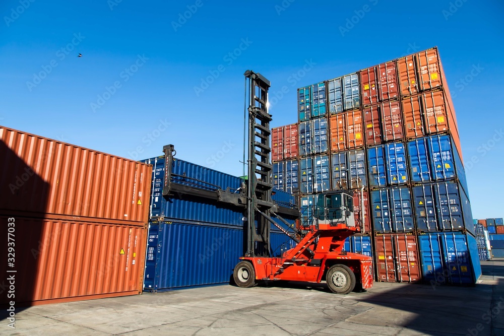 Crane lifting up container in yard. Forklift truck lifting cargo ...