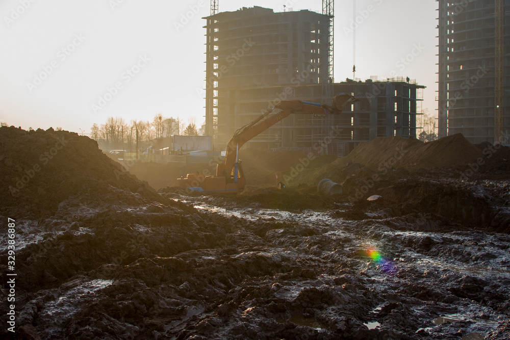 Excavator at construction site on a background of a construction cranes ...