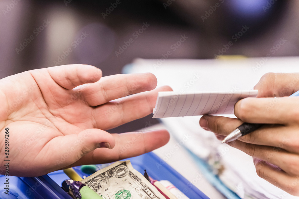 Foto de Teenage school kids passing notes in the classroom during class ...
