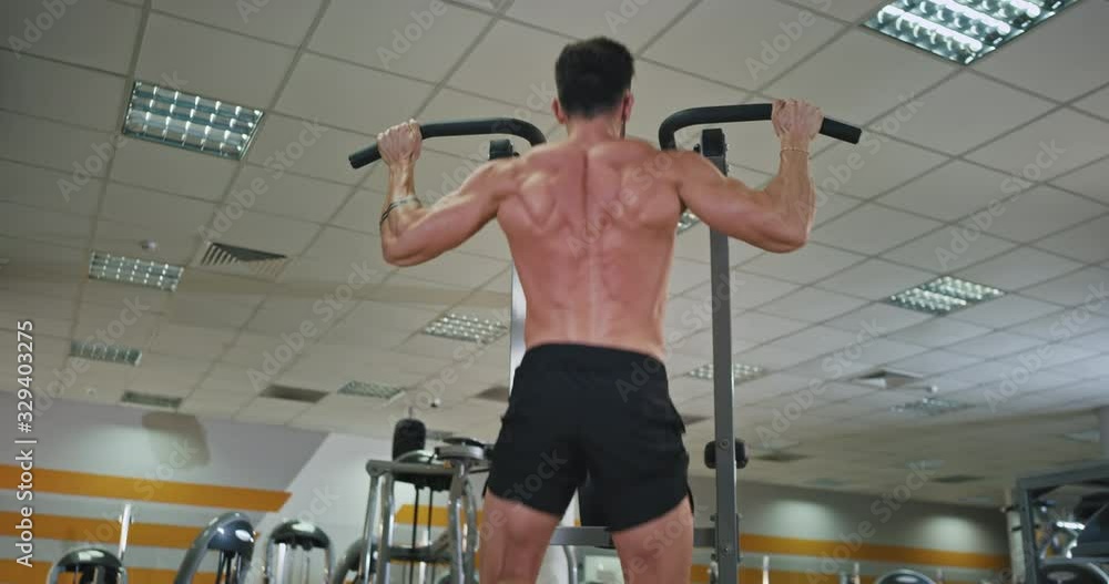In a gym class athletic guy doing exercises for his muscle to get more ...