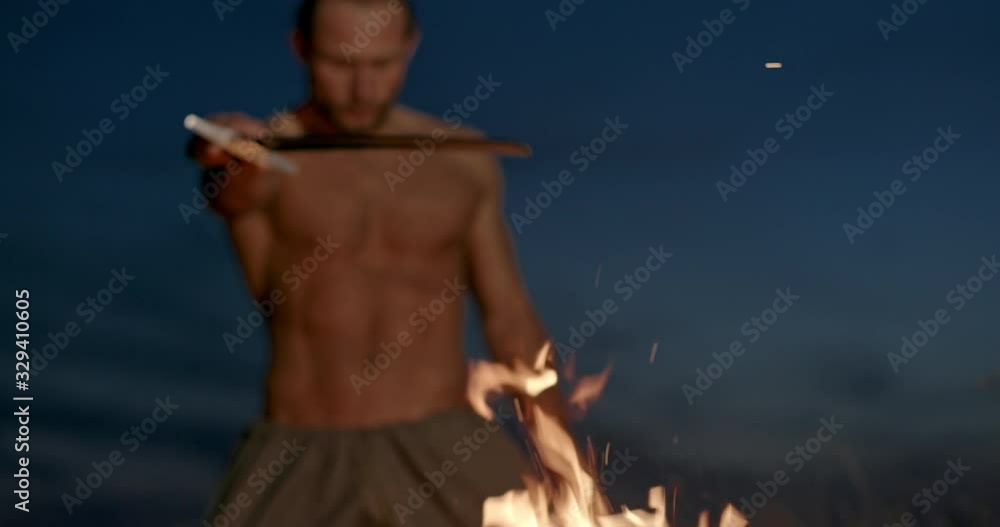 Swordsman performing a symbolic ritual at night heating the tip of his ...