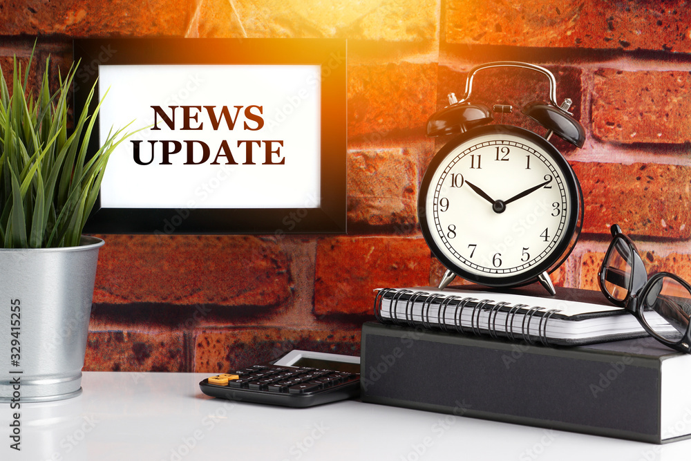NEWS UPDATE text with alarm clock, books and vase on brick background ...