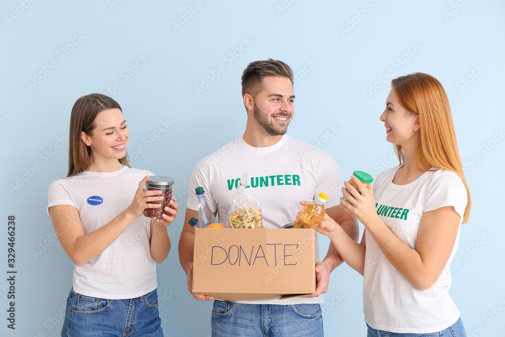 Volunteers with donations for poor people on color background Stock ...