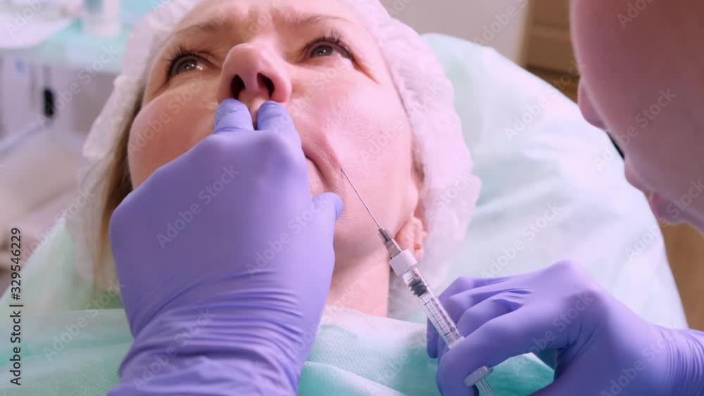 Middle aged woman 50 getting a lifting injection of an injection of ...