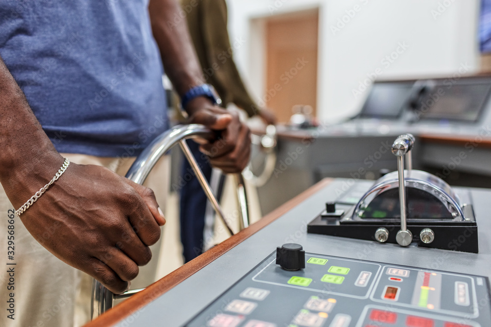 Captain's hands at the helm of a boat.Captain's hands at the helm of a ...