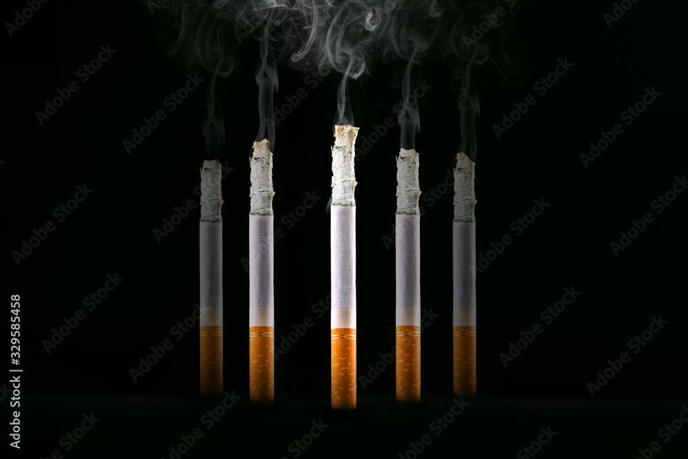 Cigarettes burning on black background. Stop smoking. Stock Photo ...
