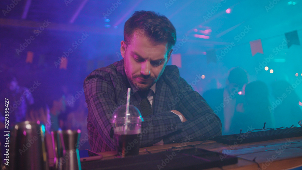 Tired young businessman falling asleep of alcohol on bar counter trying ...