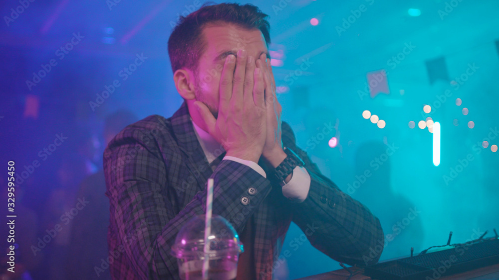Tired young businessman falling asleep of alcohol on bar counter trying ...