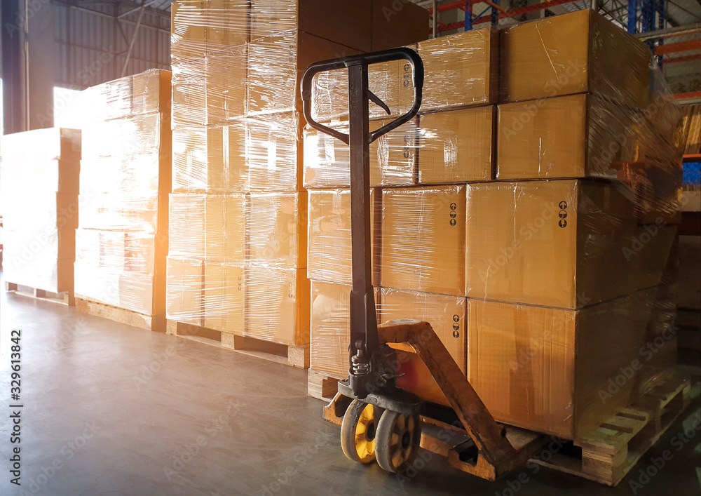 Interior of warehouse, stack package boxes on pallets and hand pallet ...