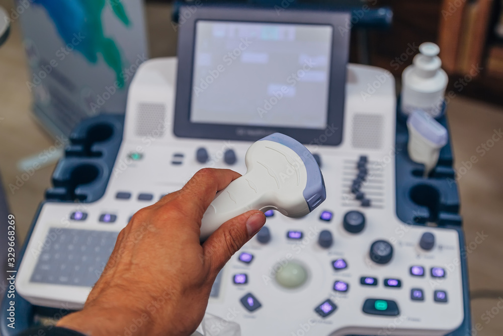Doctor's hand holding ultrasound probe of ultrasound scanner for ...