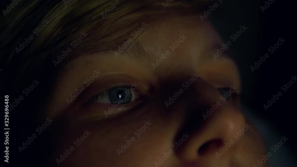 Young girl with blue eyes looking at her smartphone and scrolling ...