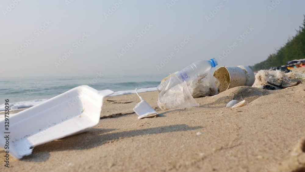 4K Garbage foam containers falling down on sand. Polluted beach in Asia ...