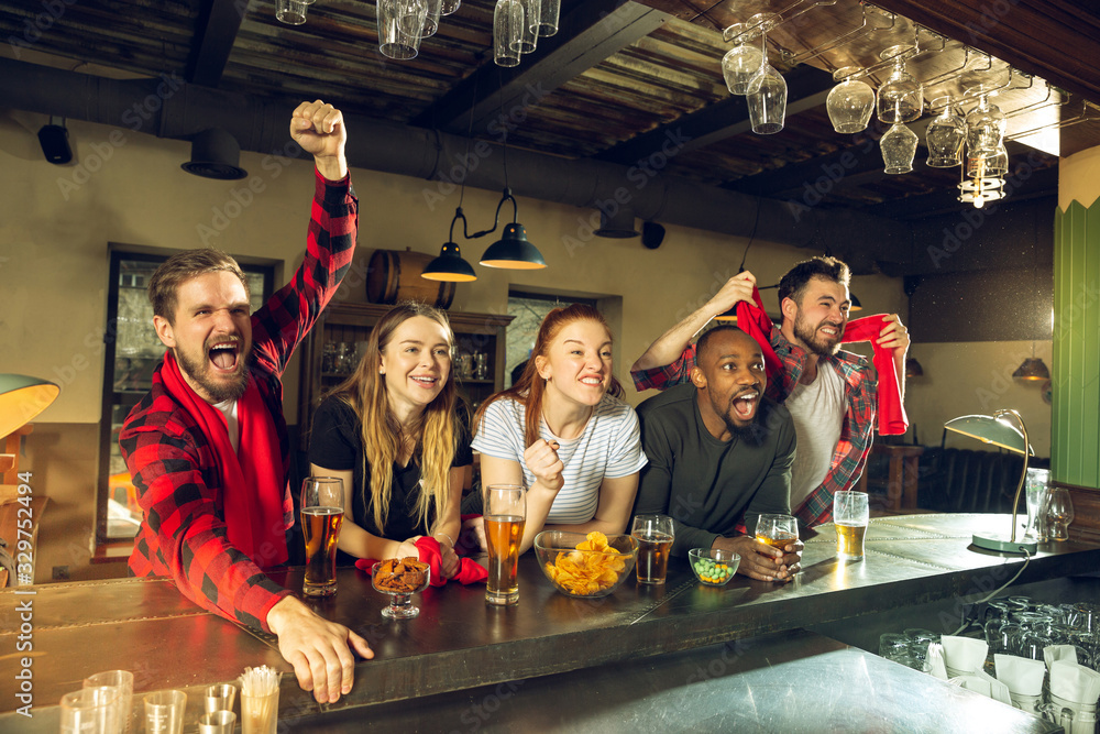 Sport fans cheering at bar, pub and drinking beer while championship ...