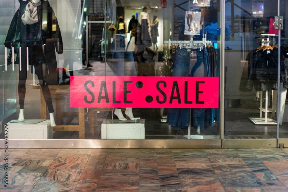 A shop front display. Sale advertisement at a clothing store. Pink ...