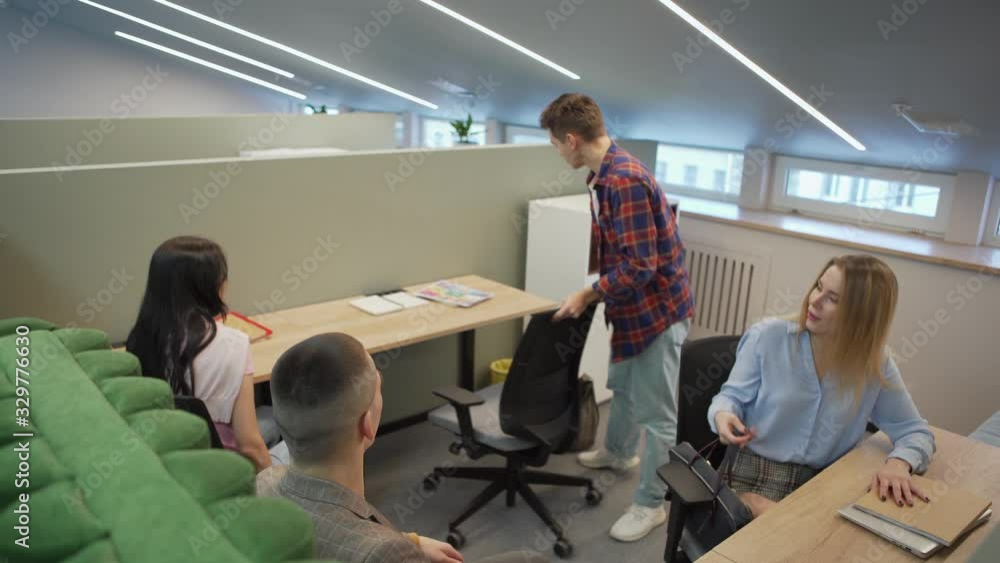 Group of office workers finishing workday, standing up, saying goodbye ...