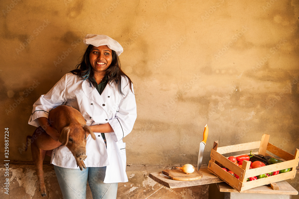 Attractive Indian woman cook posing with red pig. Closeup portrait of ...