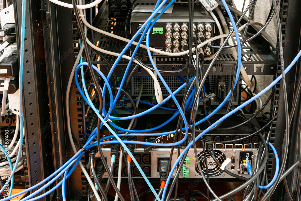 Convoluted mess of power sockets and tangled electrical cables tied ...