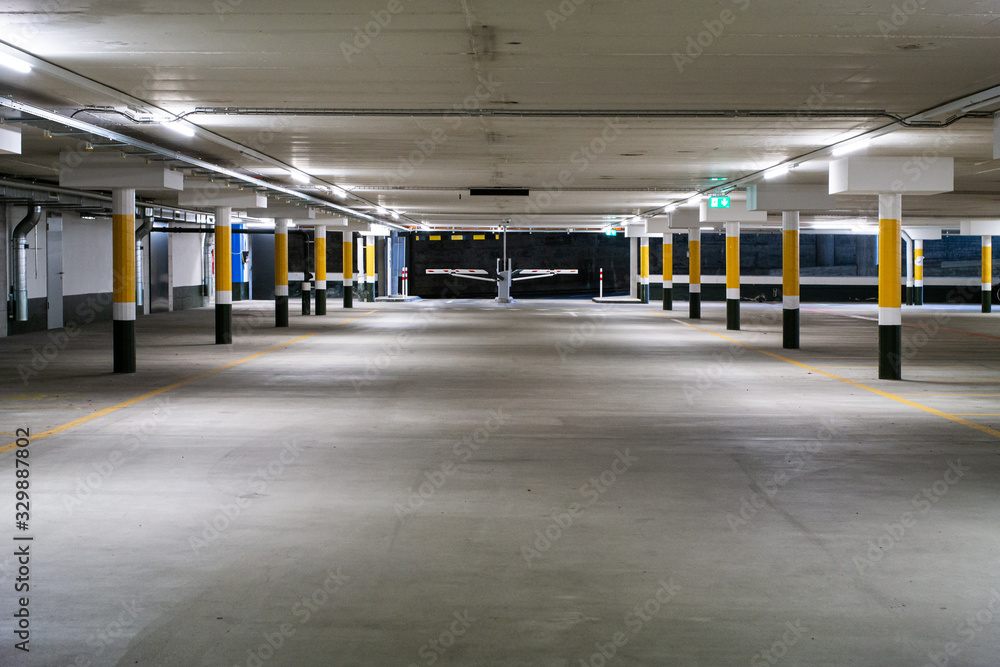 Inside underground large empty parking lot with barrier entrance at ...