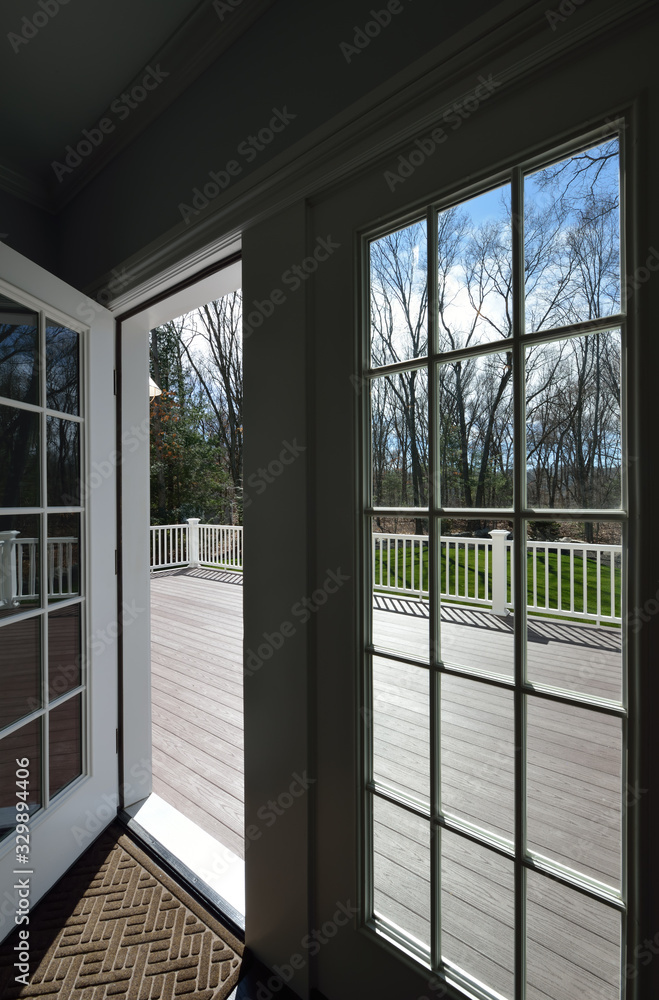 Garden deck view through the window glass. French door opening to a ...