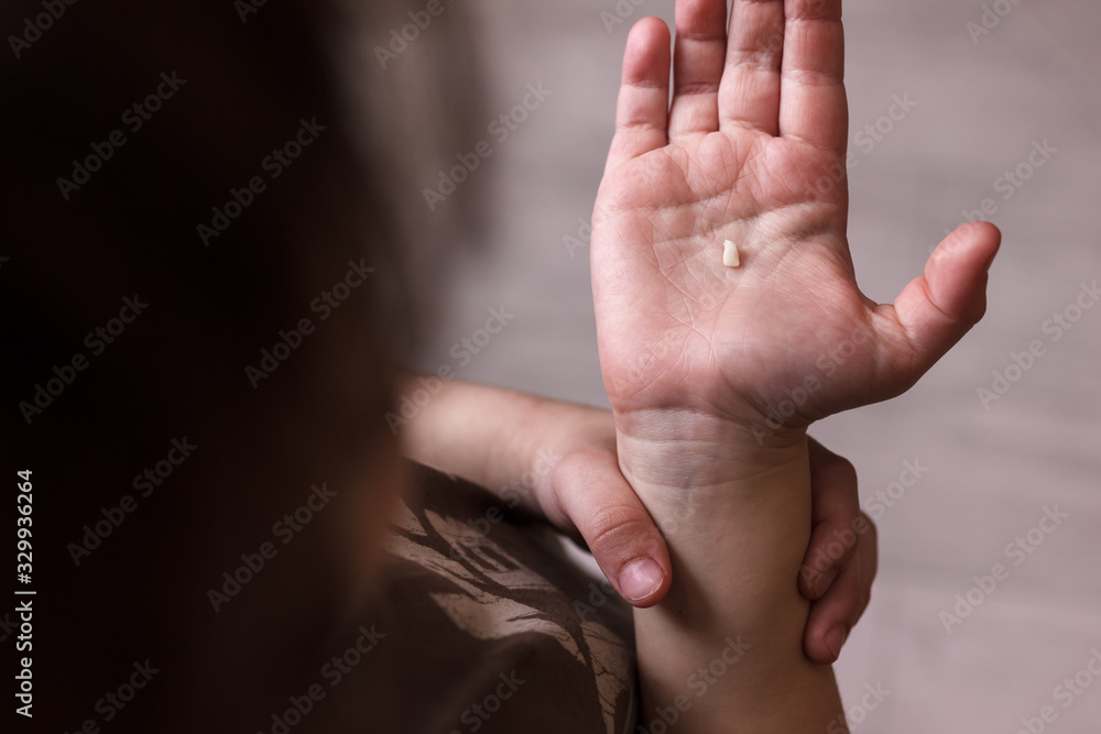 tooth in a hand after extraction on white background, lost your tooth ...