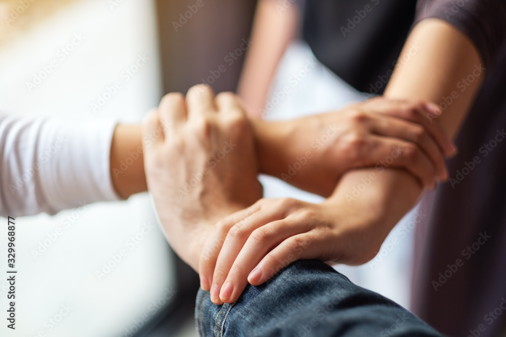 People putting their hands in a circle together for unity and teamwork ...