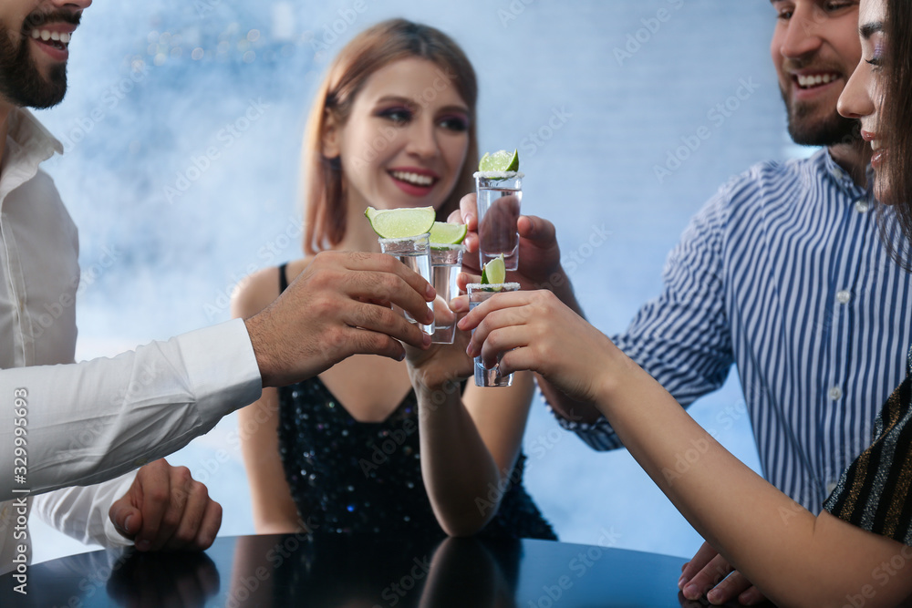 Young people toasting with Mexican Tequila shots at table in bar Stock ...