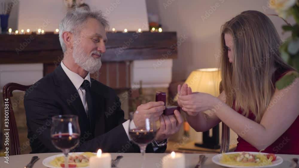 Confident senior man making marriage proposal to young woman during ...