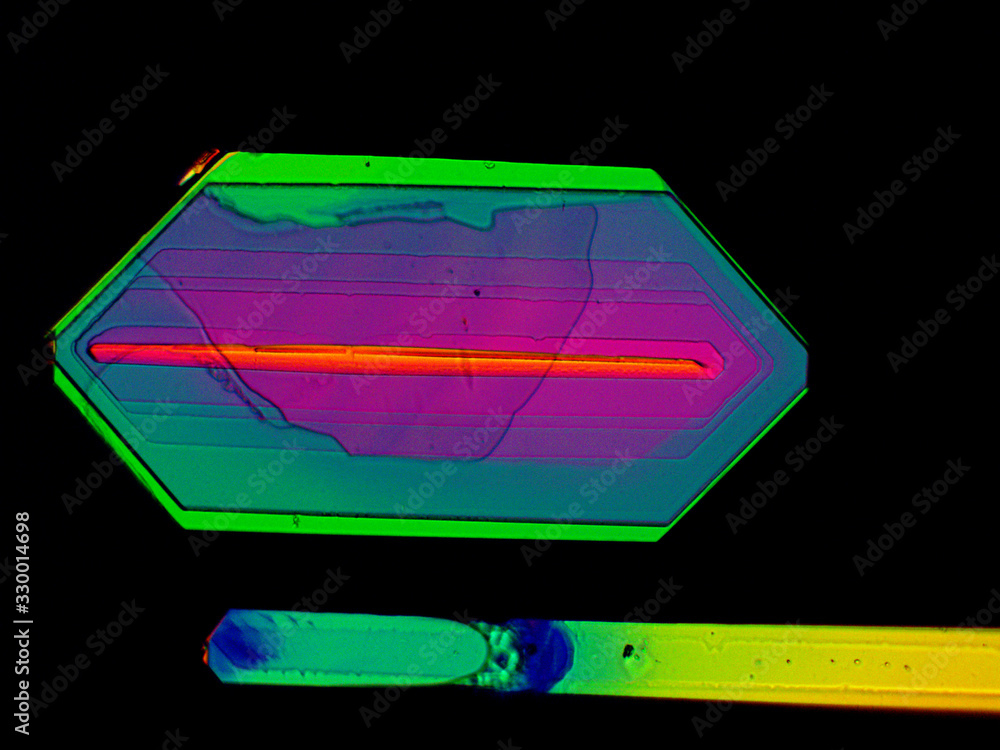 Thin layer of crystals of different chemicals seen in a microscope with ...