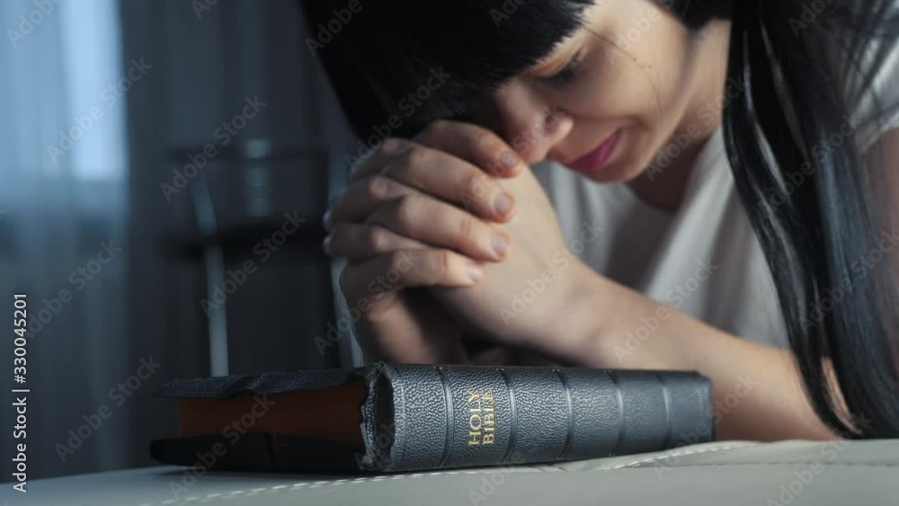 girl lifestyle praying indoors at bedtime on bible. religion concept ...