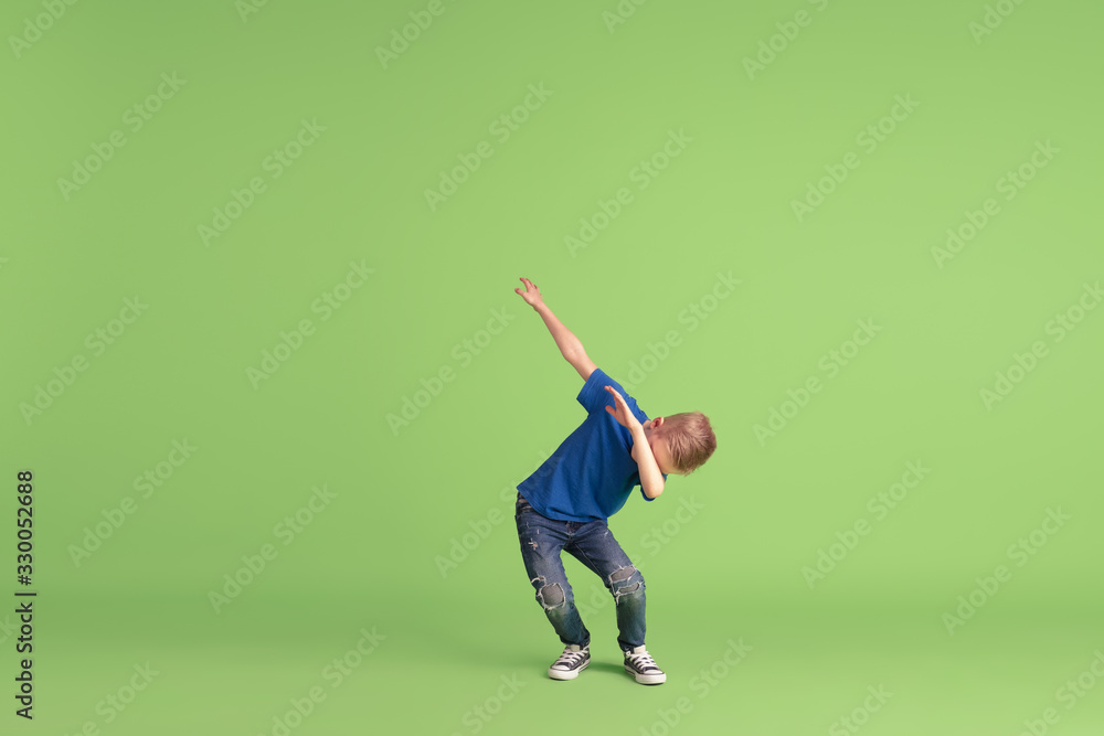 Dabbing. Happy boy playing and having fun on green studio background ...