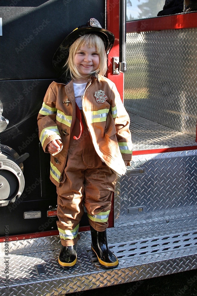 Full Length Portrait Of Cute Girl In Firefighter Uniform Standing On ...