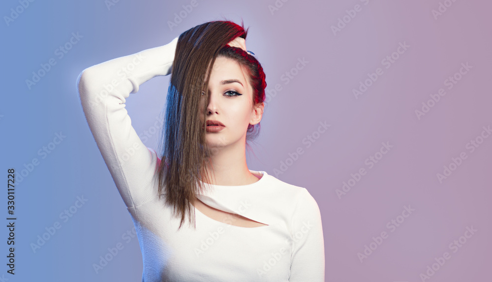 portrait of cocky girl with long ponytail hair on studio background ...
