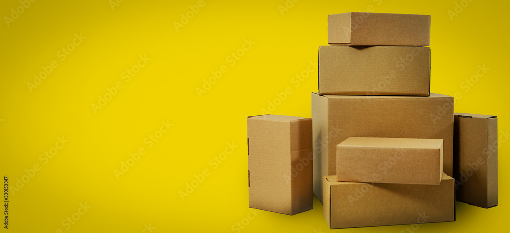 shipping and delivery - blank cardboard boxes on yellow background with ...