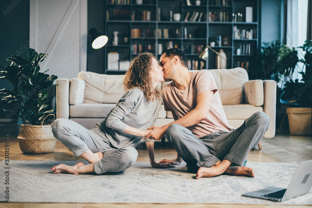 Calm couple in pajamas meditating, listening spiritual practices ...