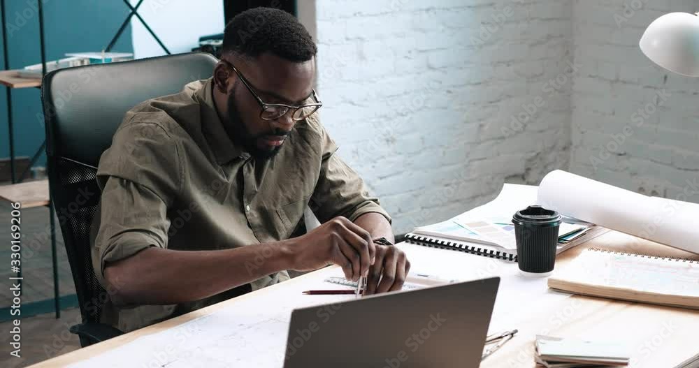 Architect drawing blueprints with professional Compass in Loft office ...