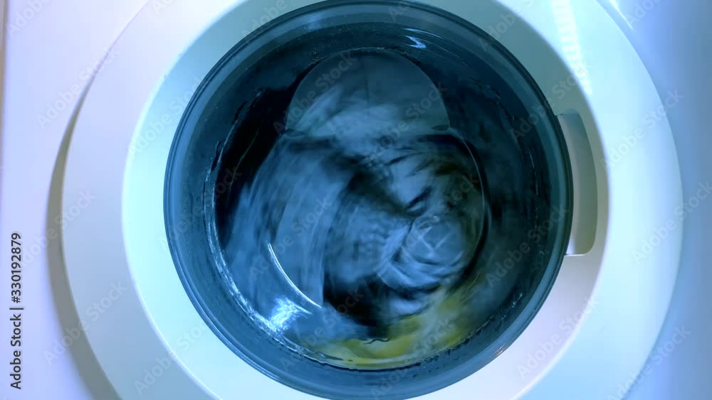 Washing machine washing clothes. Close up view of laundry is washed ...
