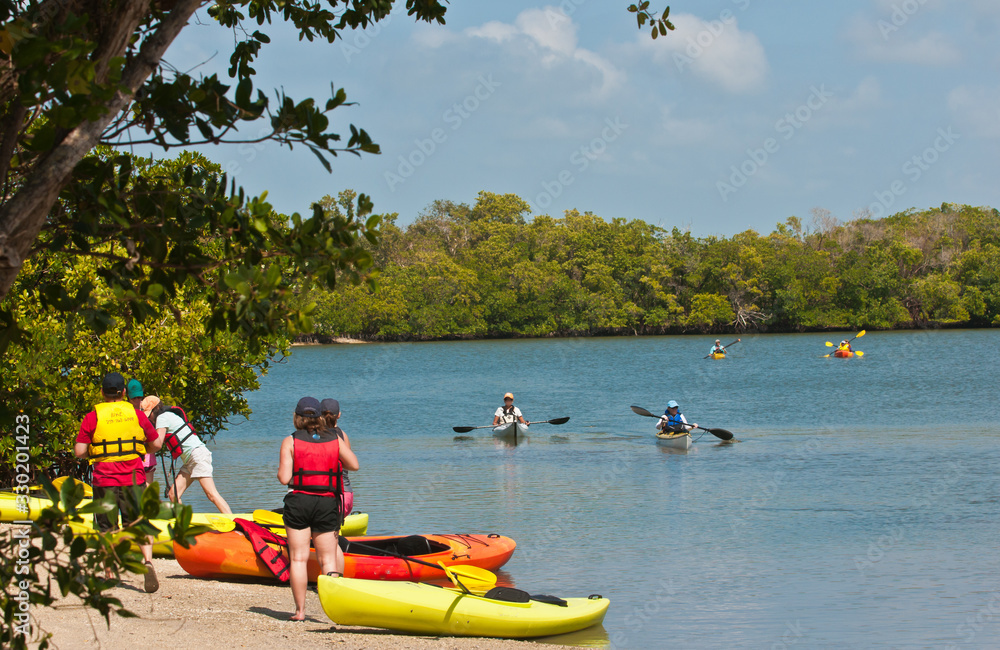 Back view, far distance of male and female kyakers pull kyaks into ...